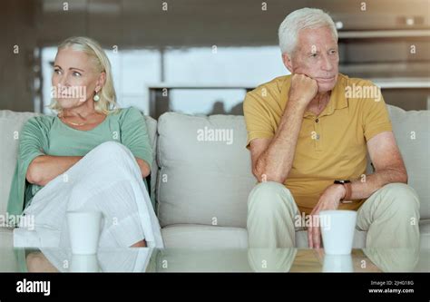 Unhappy Elderly Couple Sitting On A Sofa Together After Arguing Senior