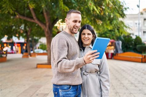 Man And Woman Couple Smiling Confident Using Touchpad At Park Stock