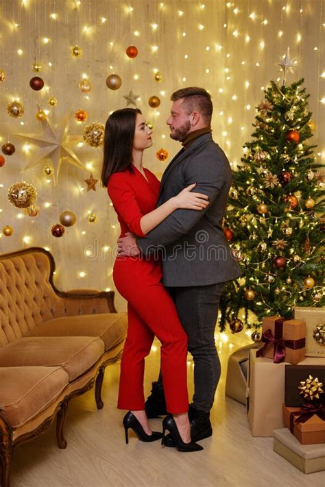 Gentle Cute Couple In Festive Clothes Hugging Near Christmas Tree Stock