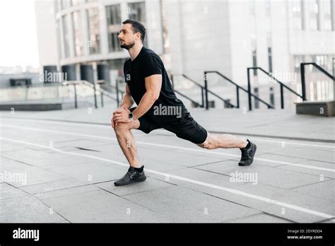 Strong Man Doing Lunge Forward Side View Sport In Big City Concept