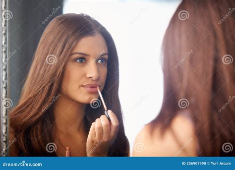 Luscious Glossy Lips A Young Woman Putting On Lipgloss In Front Of The