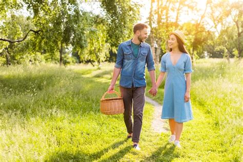 Free Photo Young Multiracial Enamored Couple Walking In Park Holding