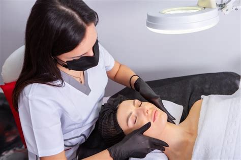 Premium Photo Professional Cosmetologist Doing Facial Massage To