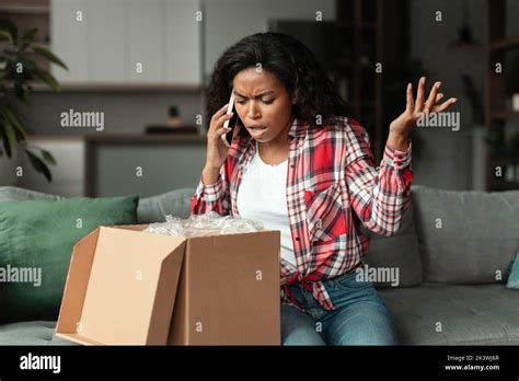 Sad Frustrated Millennial African American Woman Opening Cardboard Box