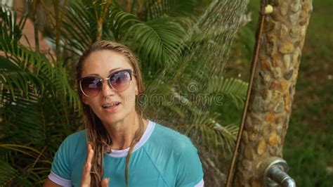 Woman Taking A Shower In Garden Near Hotel Girl In Blue Swimsuit