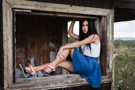Young Adult Seductive Brunette In Blue Skirt And White Shirt Posing In