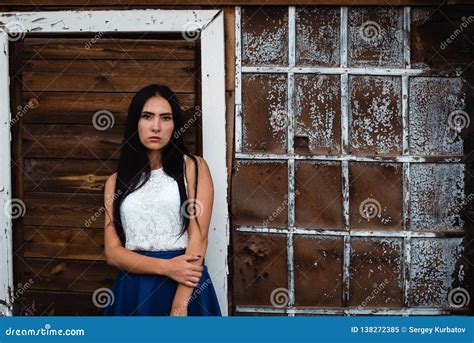 Young Adult Seductive Brunette In Blue Skirt And White Shirt Posing In