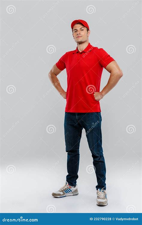 Young Delivery Man Wearing Uniform Posing And Looking At Camera Stock