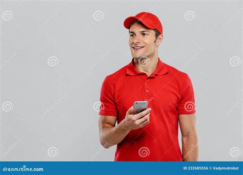 Young Delivery Man Wearing Uniform Smiling And Looking At Camera Stock