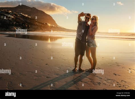 Romantic Young Couple Taking Selfie At The Beach Young Man And Woman
