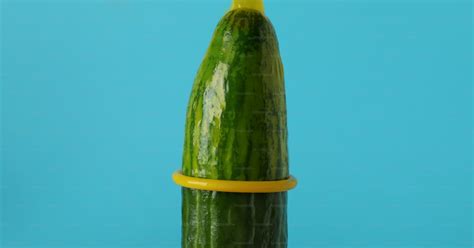 Cucumber With Yellow Condom On Blue Background Photo Cucumber Image