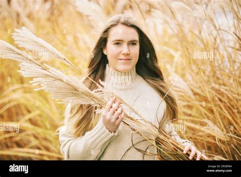Fall Portrait Of Young Pretty Girl Posing Outside With Pampas Grass