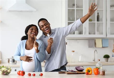 Joyful Pregnant Black Couple Having Fun While Cooking Stock Image