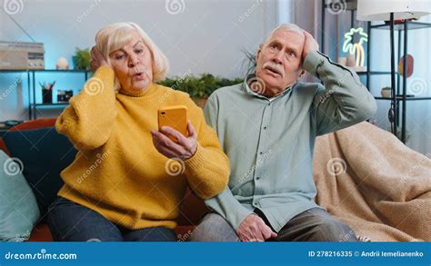 Senior Man Woman Couple Use Smartphone Surprised By Bad News Fortune