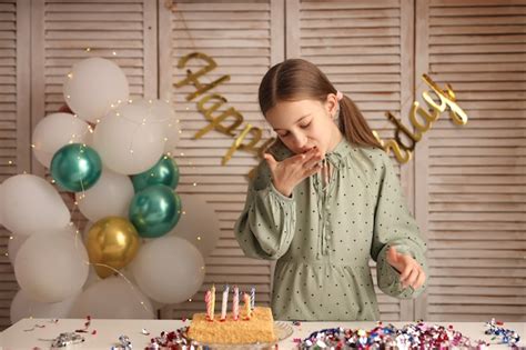 Premium Photo A Girl Blows Out Candles On A Birthday Cake