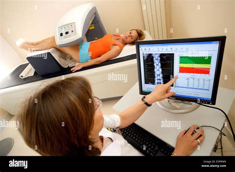 A Doctor Uses A Bone Densitometer To Measure The Optical Density Of The