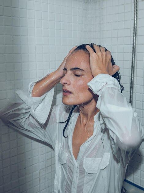Premium Photo Serious Female In White Shirt Touching Wet Hair While