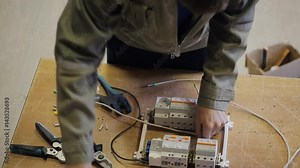 Professional electric inserts connecting wires to automatic fuses. Different settings for protection against short circuit, overheating in switchboard on background of wooden table. Equipment with