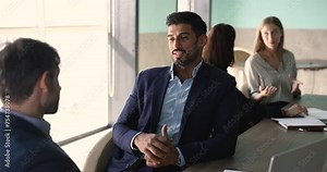 Smiling Indian businessman lead talk to partner met in coworking space, colleagues having formal conversation conclude agreement, parties engaged in discussion, shake hands, finish negotiations. Deal