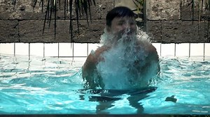 Teenager jumping in swimming pool, super slow motion 240fps