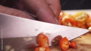 Close-up of cutting chilli peppers with a sharp knife into small pieces. Slicing chilies for cooking