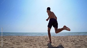 Male running and jumping in sea water, cinematic steadicam trekking shot, SLOW MOTION