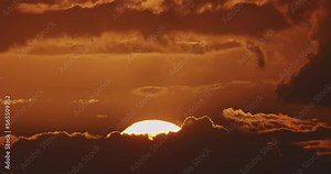 Sunrise timelapse, close up of big sun rising through clouds. Beautiful nature background cloudscape time laps.