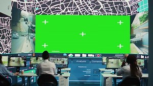 Shipping agency workers examine satellite map with huge greenscreen display, monitoring parcels and orders for clients. Employees using surveillance CCTV footage to get updates. Camera B.