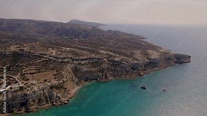 4K drone. Matala is a is a village located in the south of Crete, Greece. With a beautiful beach with cliffs, caves, ruins, restaurants and shops. Is a hippie area on this paradisiac Island