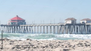 Retro huntington pier, surfing in ocean waves and sandy beach, California coast near Los Angeles, USA. American diner, sea water, beachfront boardwalk, summer vacations. Seamless looped cinemagraph.