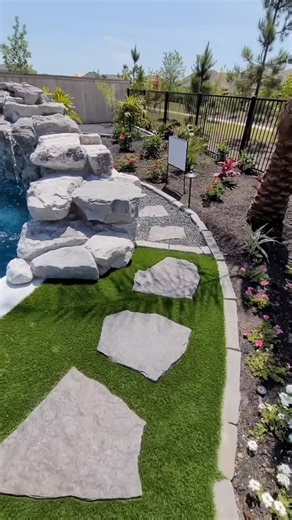 This freeform pool hits DIFFERENT 😮‍🔥💦 Not your old-school kidney-shaped freeform… this one is modern, bold, and built to stand out. ✔️ Modern gray rock waterfall grotto vibes ✔️ Infinity-edge spa spilling over ✔️ Turf inlays for that clean, low-maintenance finish ✔️ Raised seating area ✔️ Layered waterfalls lush landscaping to tie it all together Designed and built right here in Texas. We serve homeowners across Houston,Dallas, Austin, San Antonio, and surrounding areas who want something ne