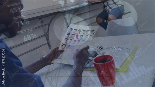 Man opening folded sheet, scanning roster at table while data overlays overlaying faces for hiring