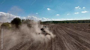 Soil cultivation field use tractor. Disk harrow on plowing field. Cultivated land and soil tillage. Tractor with disc cultivator on land cultivating. Tractor disk harrow on field cultivation.