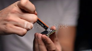 Cropped shot of unrecognizable man applying new thermal paste to PC CPU processor chip, slow motion. Servicing motherboard of dusty computer and restoring health of computer and cooling system.