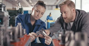 Master explaining apprentice how to measure drill parts with caliper