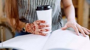 beautiful female scrolls through a magazine sitting on a chair in the office. the girl is holding a glass of coffee. Stock Video