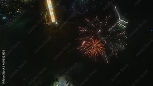 Top down above explosion of fireworks in urban city. Aerial Fireworks Waikiki beach. New Year Eve in Honolulu city. People celebrating with sparkling fireworks on Oahu island during Hawaiian vacation