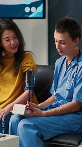 Vertical video: Senior doctor doing concussion examination for patient with cervical collar, using instrument with light. Checking eyesight and brain damage with woman wearing medical foam brace