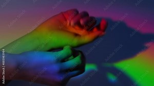 Vertical video. Hand touch. LGBT spectrum. Diversity harmony. Female palms dance gentle movement in defocused rainbow color light gradient neon glow on free space background.