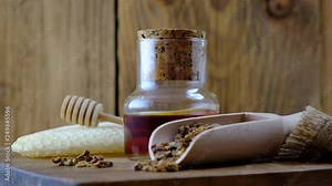 A bottle of propolis tincture and a wooden scoop of propolis granules. Medical preparations bee propolis. Bee glue. Apitherapy. How to treat bee products.