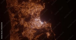 Baku (Azerbaijan) aerial view at night. Top view on modern city with street lights. Camera is zooming out, rotating counterclockwise. Vertical video. The north is on the left side
