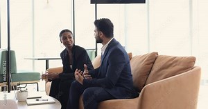 African and Indian business partners, colleagues sit in coworking office, lead formal conversation. Advisor tell to client about bank services, make recommendation, provide consultation during meeting Stock Video