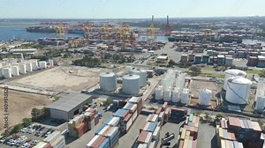 Stacked cargo containers at Port Botany terminal, global logistics ready for shipping at Botany Bay, NSW. Pan left Aerial establishing shot.