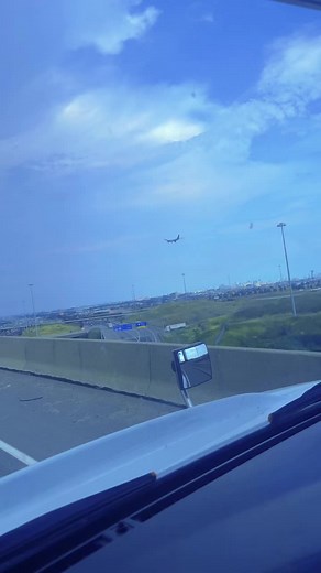 Passenger Jet Flying Low Over Urban Highway