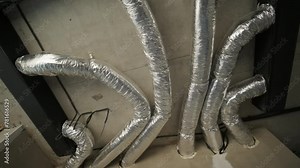 Industrial ceiling with a network of insulated ductwork, showcasing the complexity and functionality of HVAC systems in a modern building infrastructure