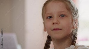 Girl with back correction braces plays music and winks to camera in living room. Child with compression fracture of spine at piano. Art therapy