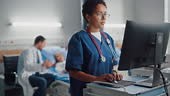 Professional Black Female Head Nurse Uses Medical Computer. In the...