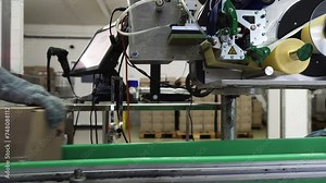 A Close-up of an automated packaging process at Medical Equipment Production. Cardboard Boxes are being sealed as an automated packaging process. Automated packaging process of Medical products.