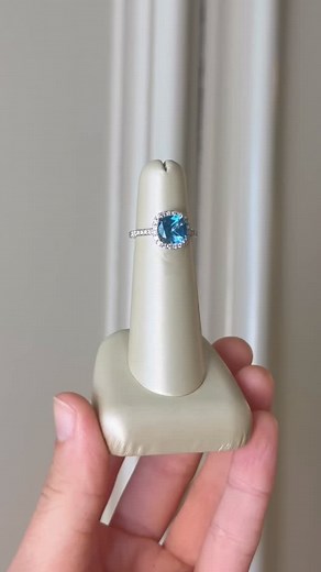 The vibrant blue of this cushion cut topaz is beautifully framed by a halo of diamonds set in 14K white gold. ✨ This ring is a stunning example of color, sparkle, and elegant craftsmanship. Our team is here to guide you through every step of the process and help you find the jewelry that feels right for you. Visit us in store to experience exceptional service and discover pieces that make you shine. | Boudreaux's Jewelers | Facebook