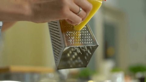 clip-3995233169-person-uses-grater-shred-fresh-ingredients-over